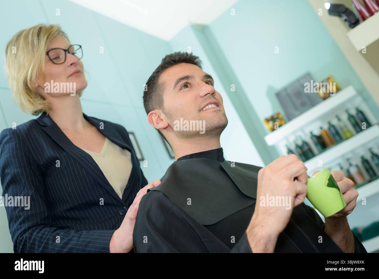 professional hair stylist finished a haircut for a handsome man Stock ...