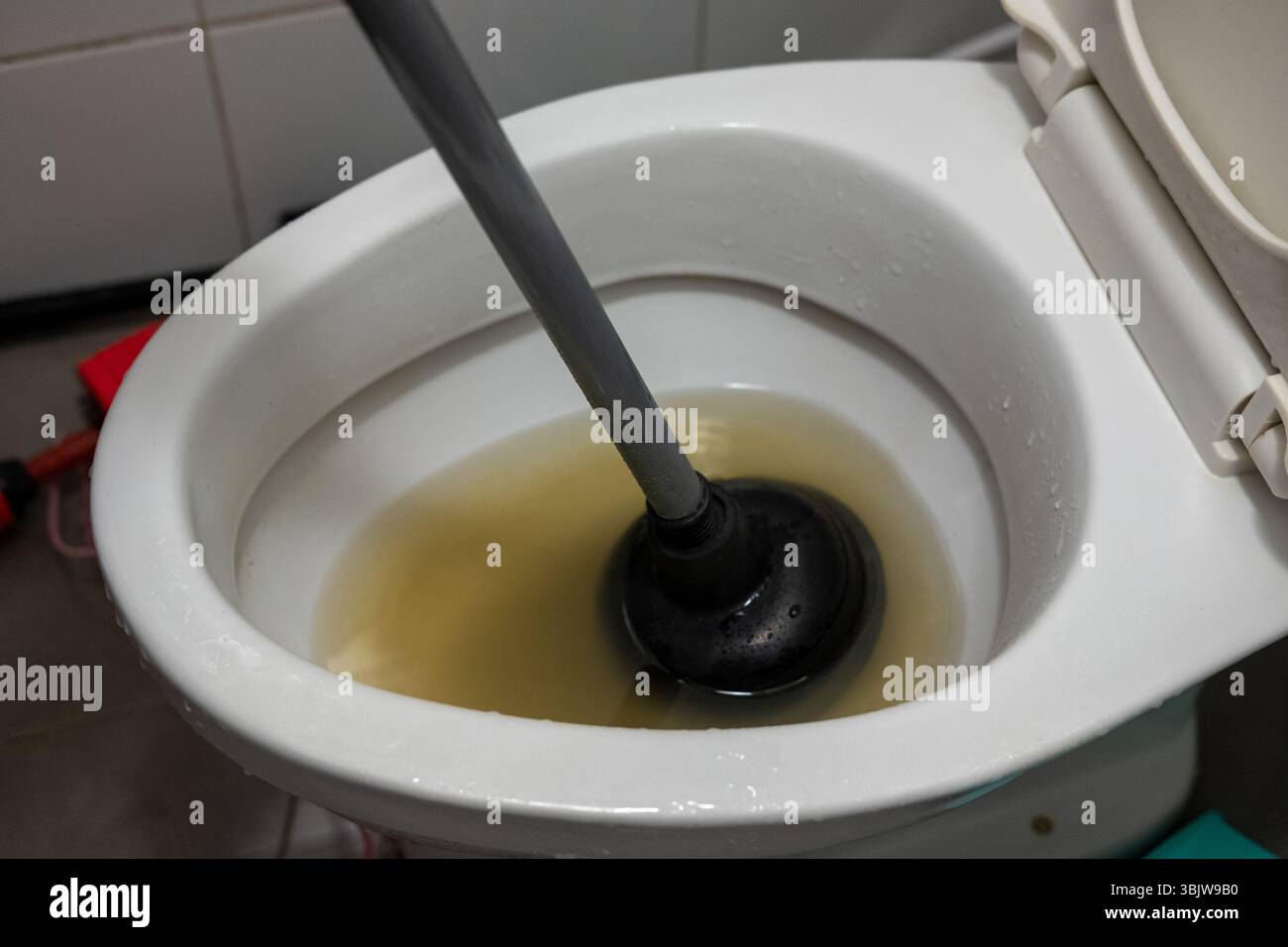 A woman's hand is using an air pump to solve a clogged toilet Stock ...