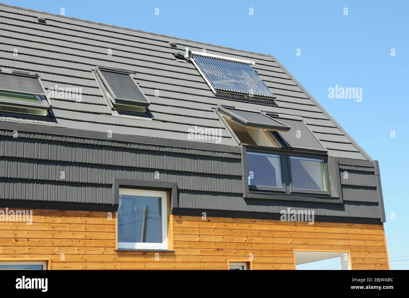 Modern passive house roof with attic skylight windows, solar water ...