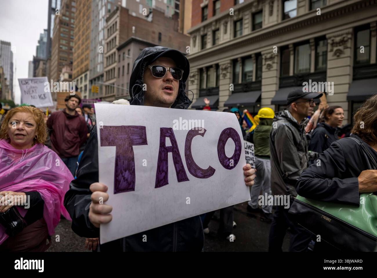?A person holds a sign that reads, “Taco,” as tens of thousands attend ...