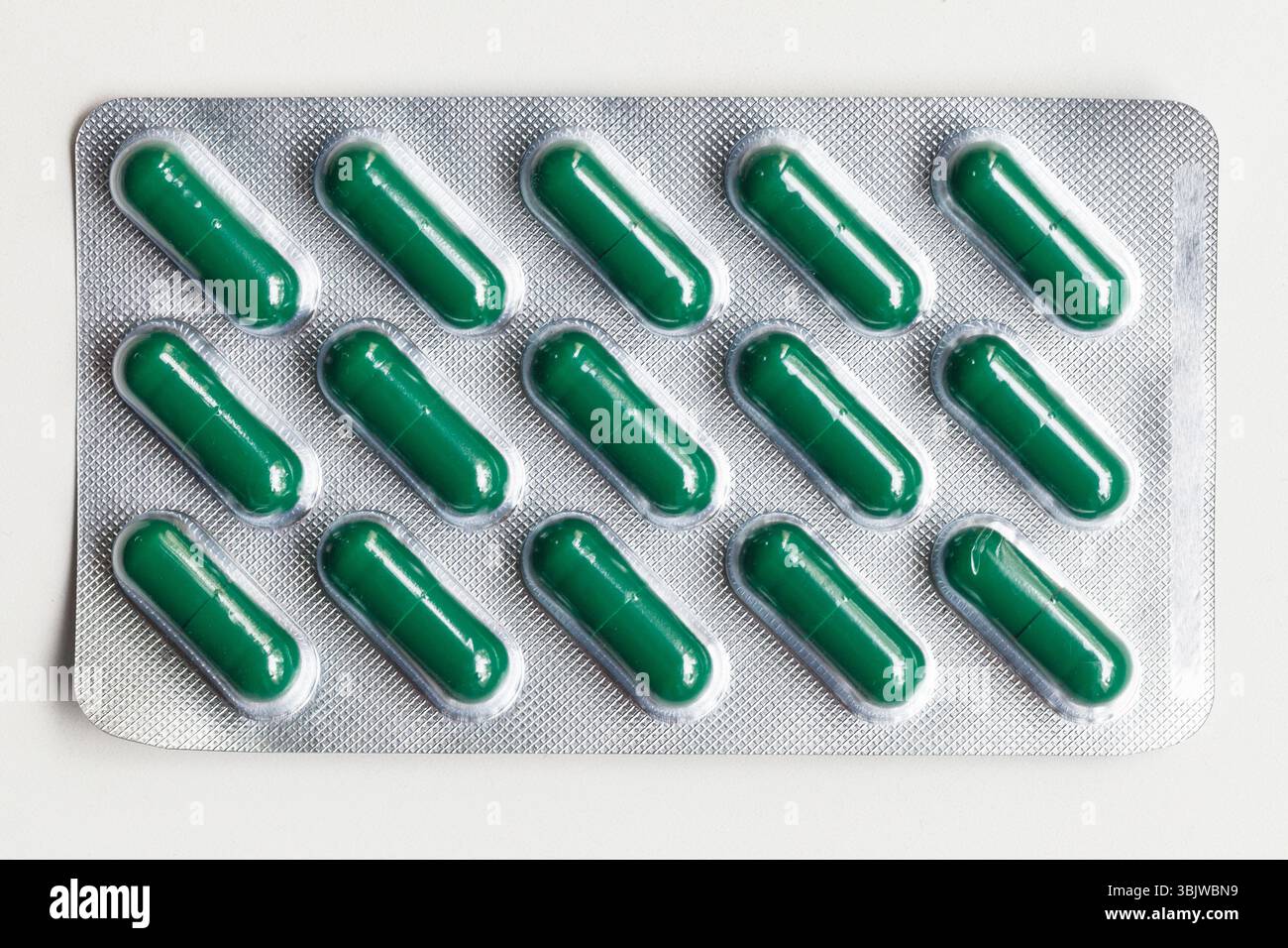 Blister pack containing green capsules commonly used for medications or ...