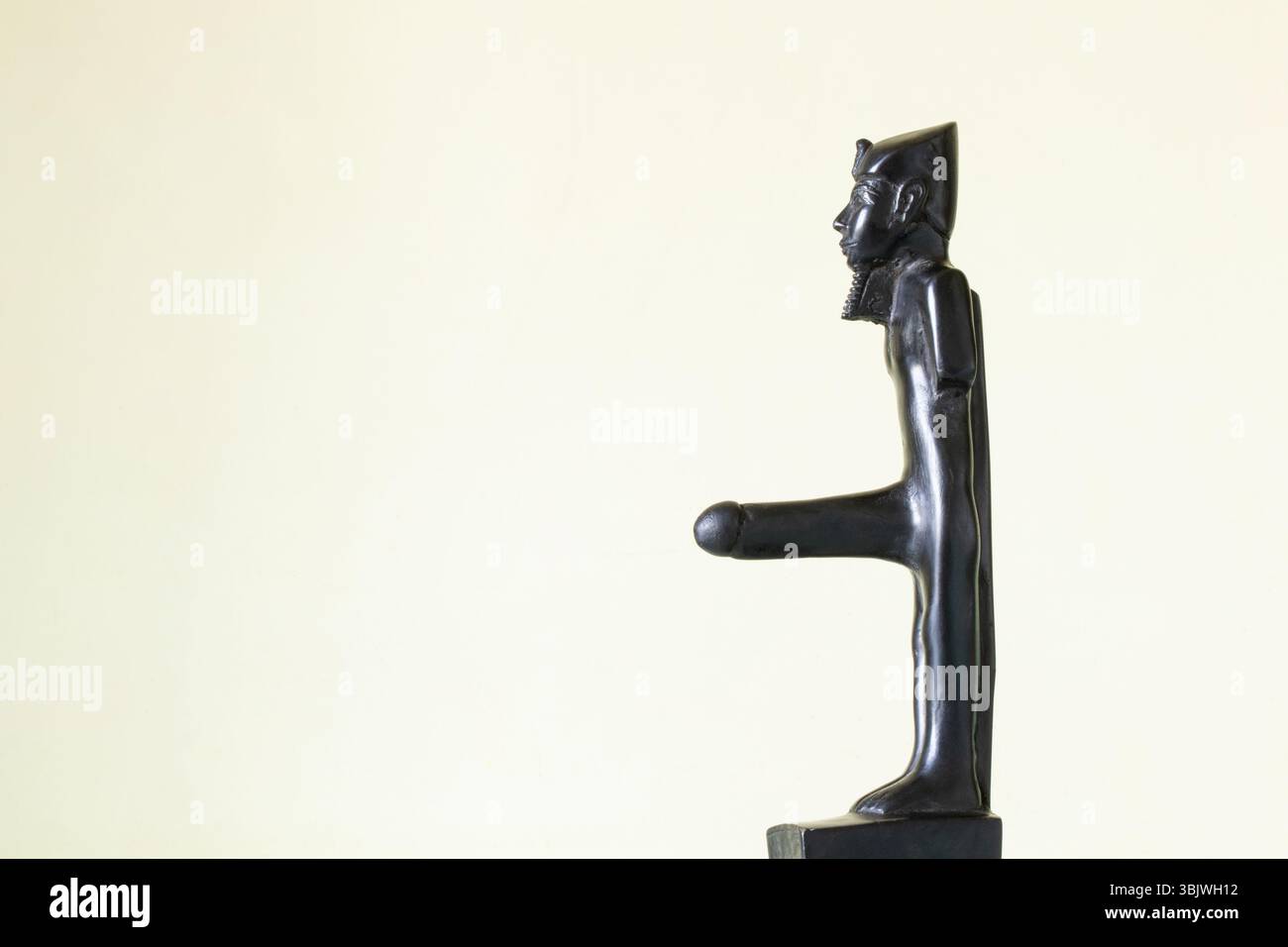 Egyptian god of fertility Min figurine on table on light background as ...