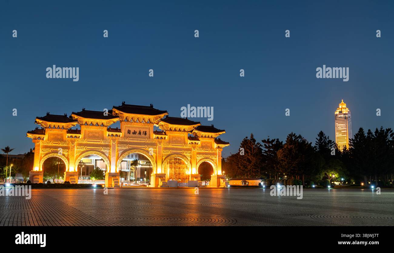 Wide twilight view of the Liberty Square Arch glowing with golden flood ...