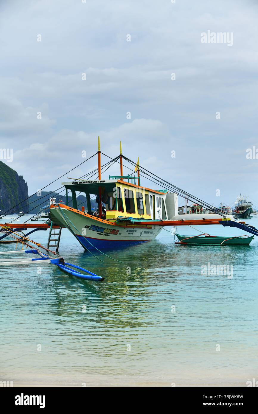 Traditional wooden and bamboo boat, Bangka docked on the harbour. EL ...