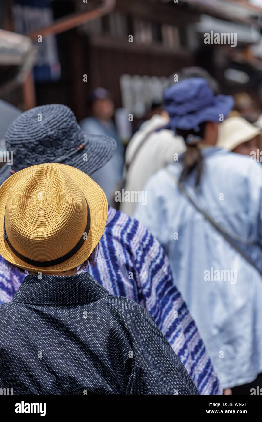 People wearing Japanese yukatas move through a crowded street at ...