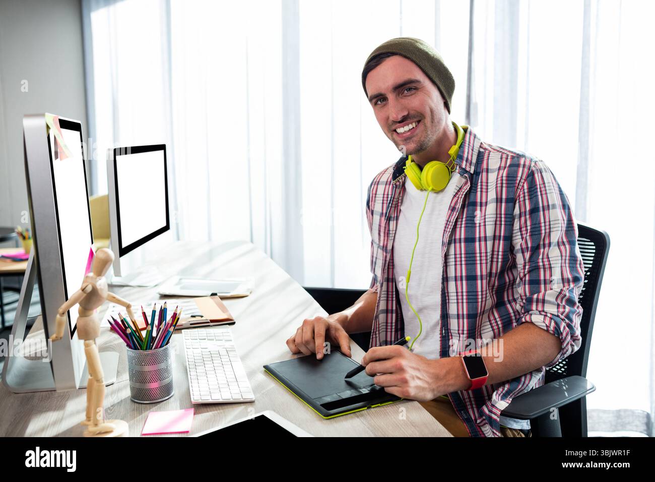 Graphic tablet stylus hovering on desk in coworking space, with dual ...