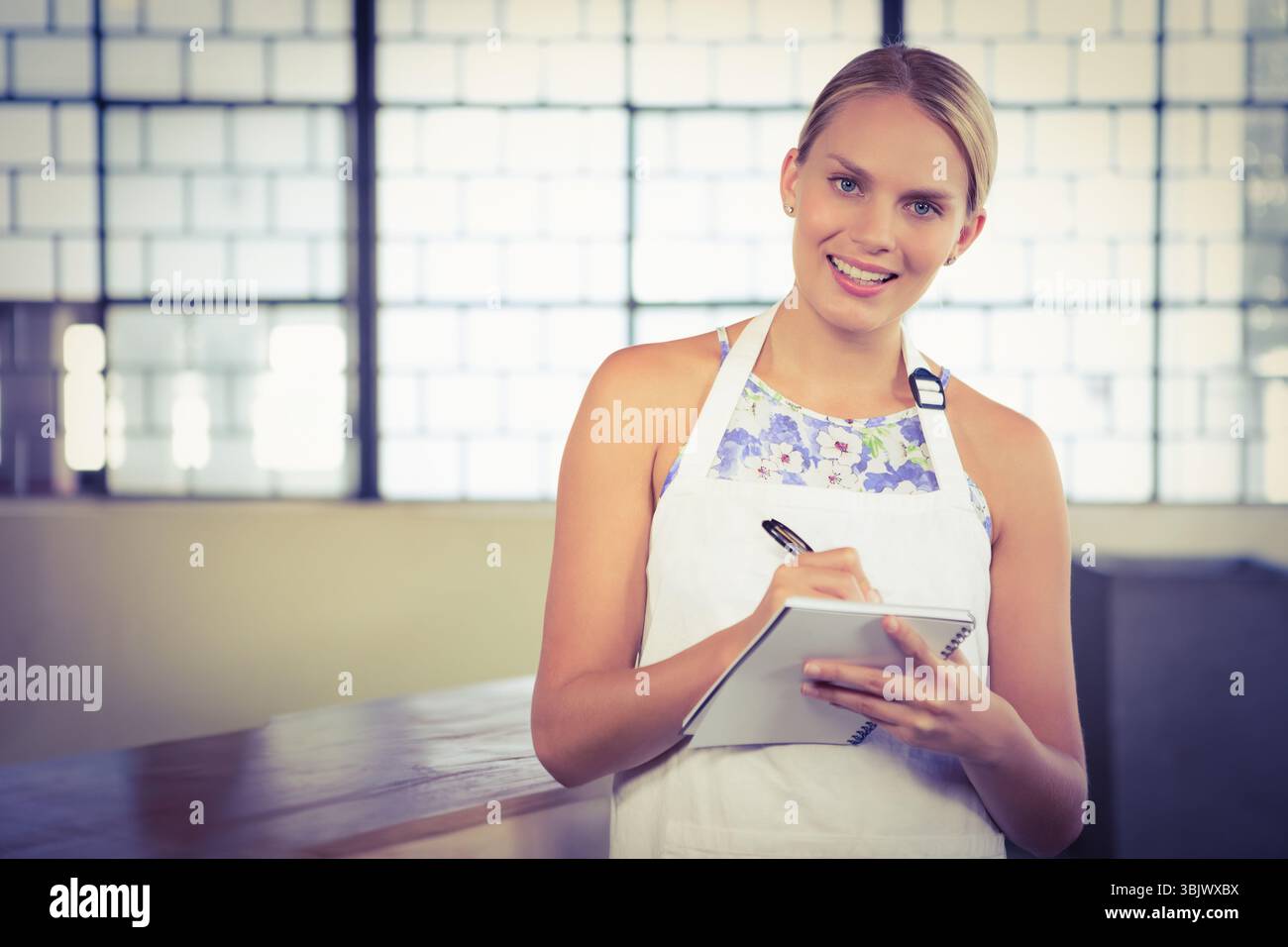 Wooden counter at cafe showing spiral notepad and pen under soft light ...