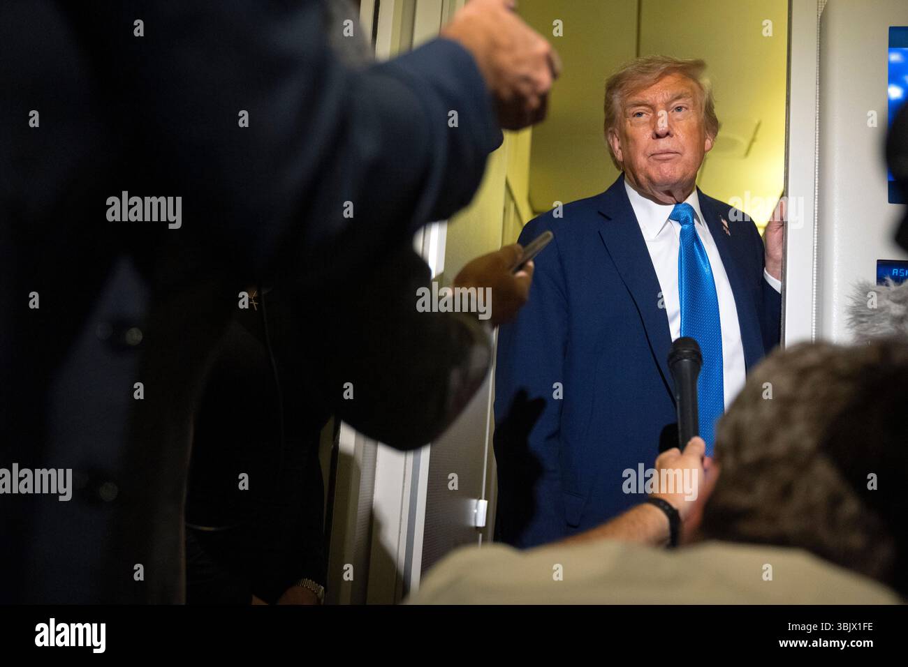 President Donald Trump speaks with reporters while flying aboard Air ...