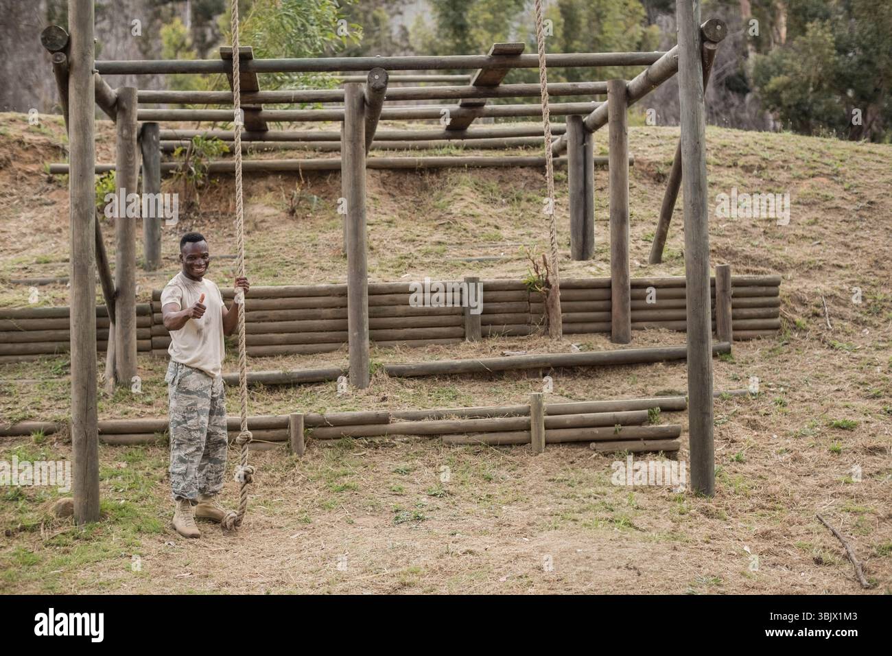African American male soldier holding rope swing and giving thumbs-up ...
