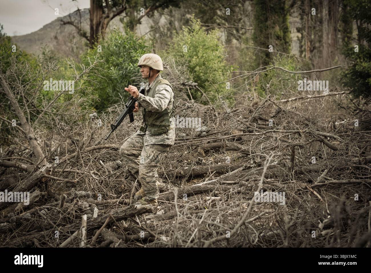 soldier in camo uniform and boots, carrying rifle and helmet, climbing ...
