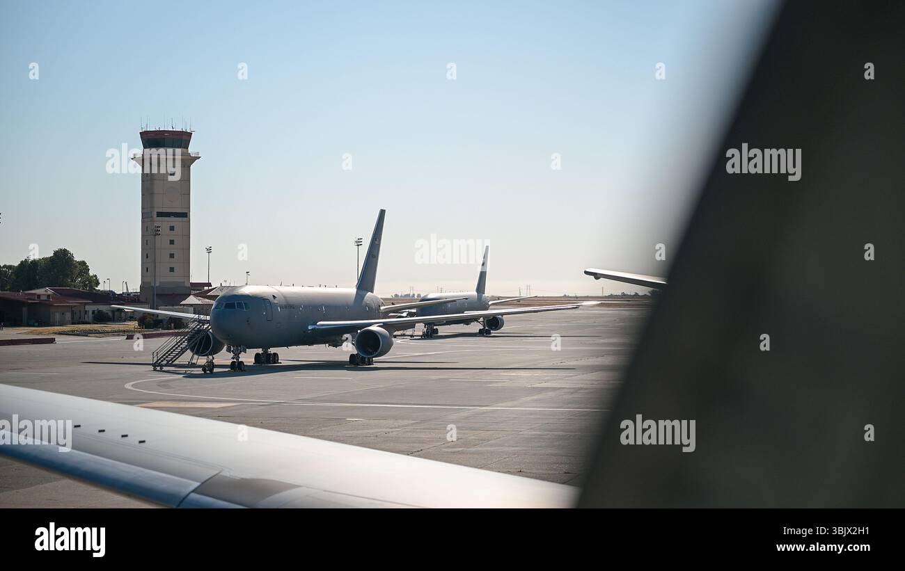 Several KC-46A Pegasus aircraft sit parked on the ramp under the ...