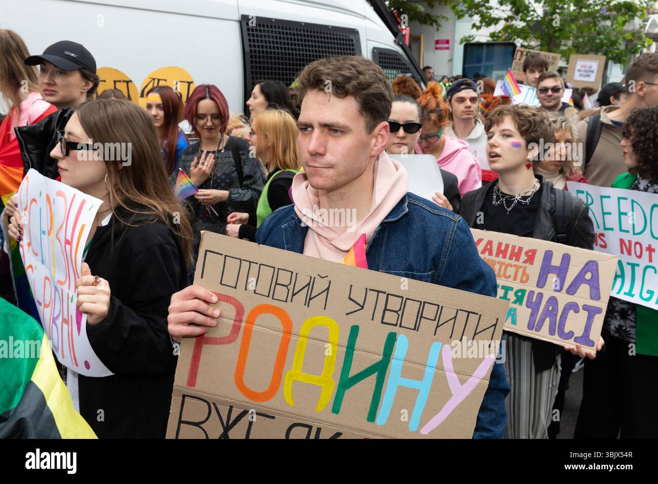 A group of people participate in a pride parade holding placards and ...