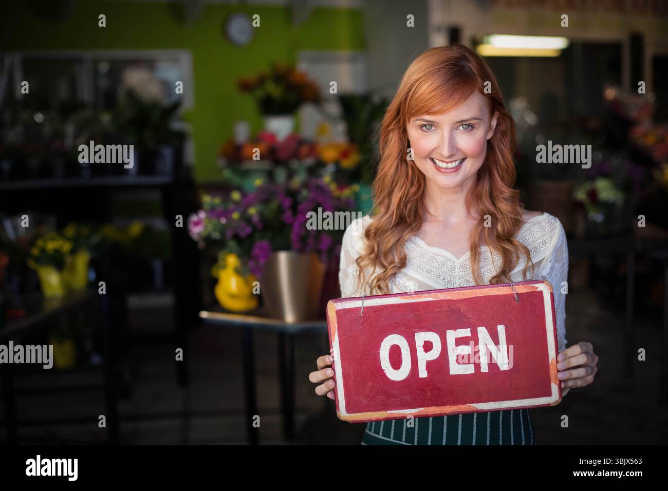Red OPEN sign displaying near entrance of flower shop, surrounded by ...