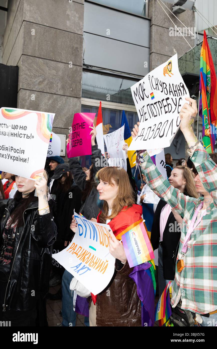 People at a pride parade hold signs and flags celebrating love and ...