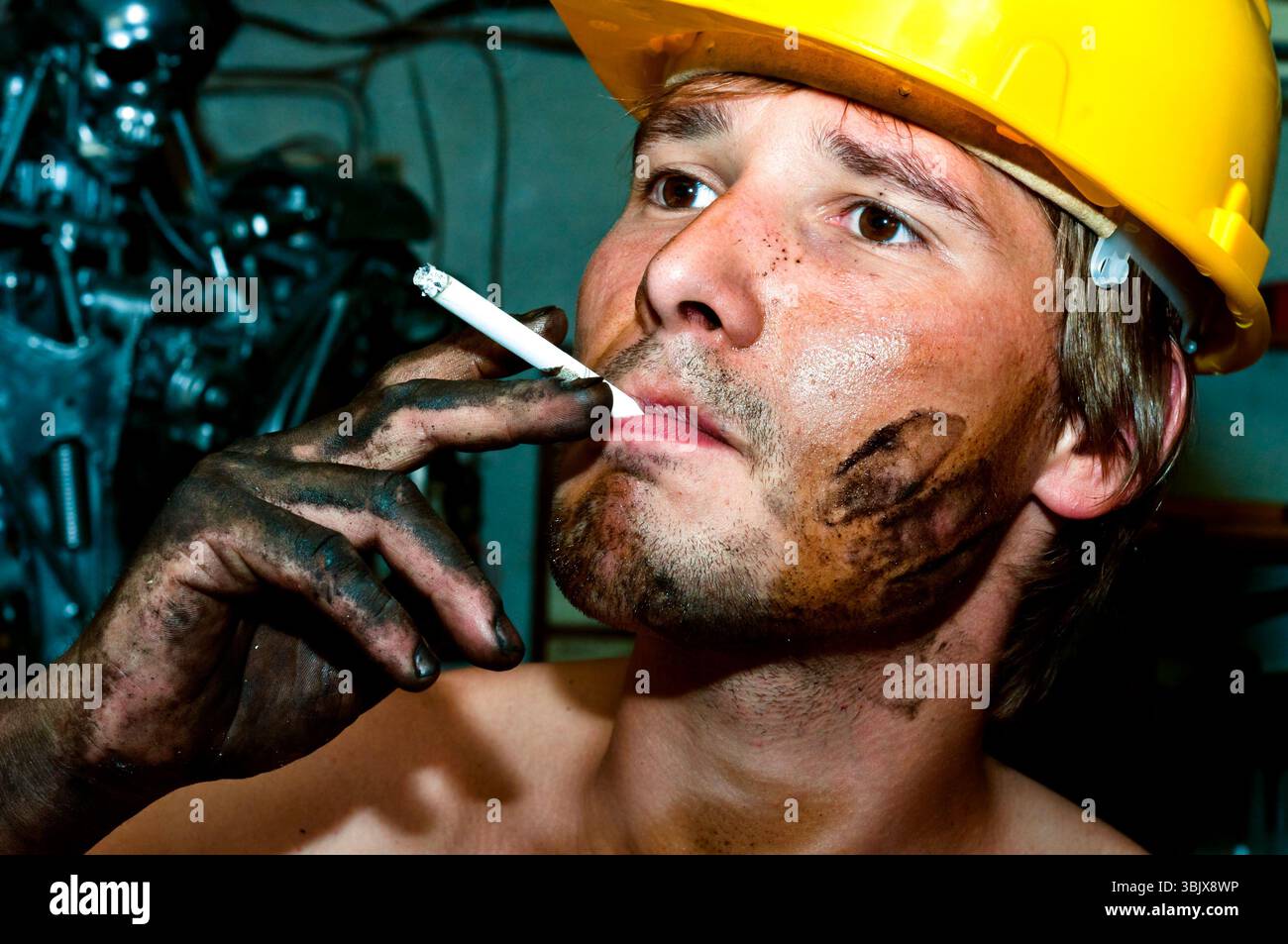 Worker covered in oil smoking Stock Photo - Alamy