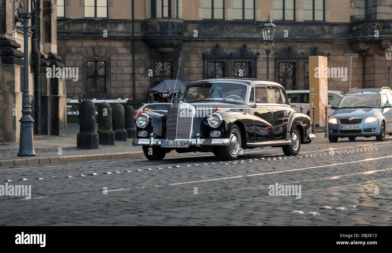 Black vintage Mercedes Benz sedan driving on city street. Old 1950s car ...