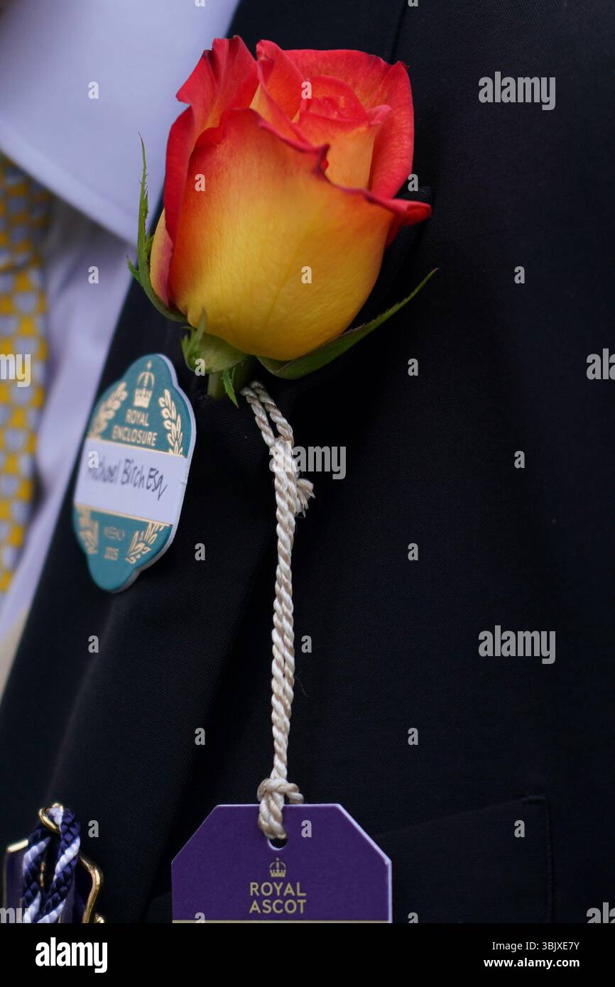 A gentleman wears a rose in his lapel next to his accreditation badges ...