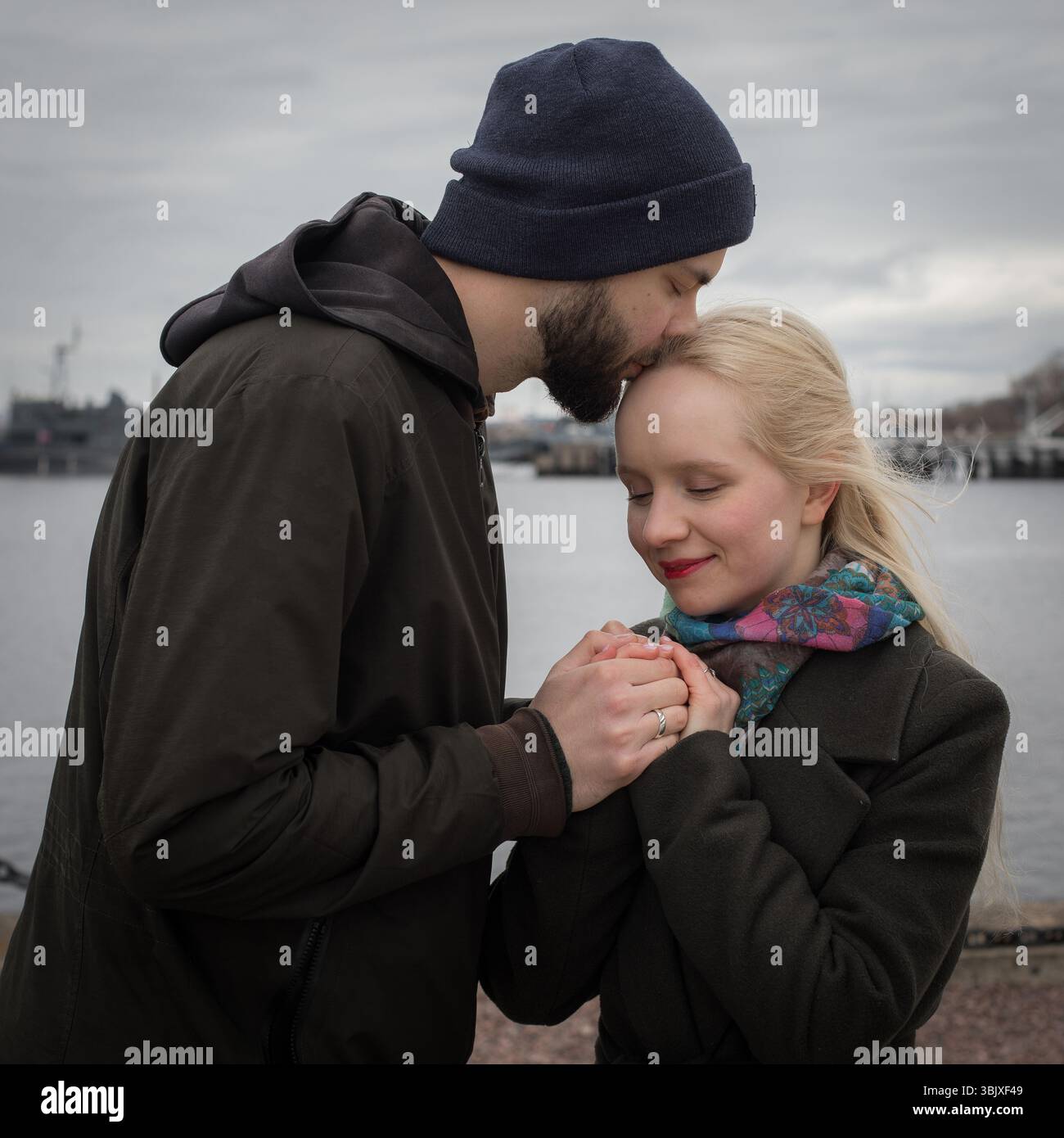 Smiling young woman with long blonde hair and man couple hugging each ...