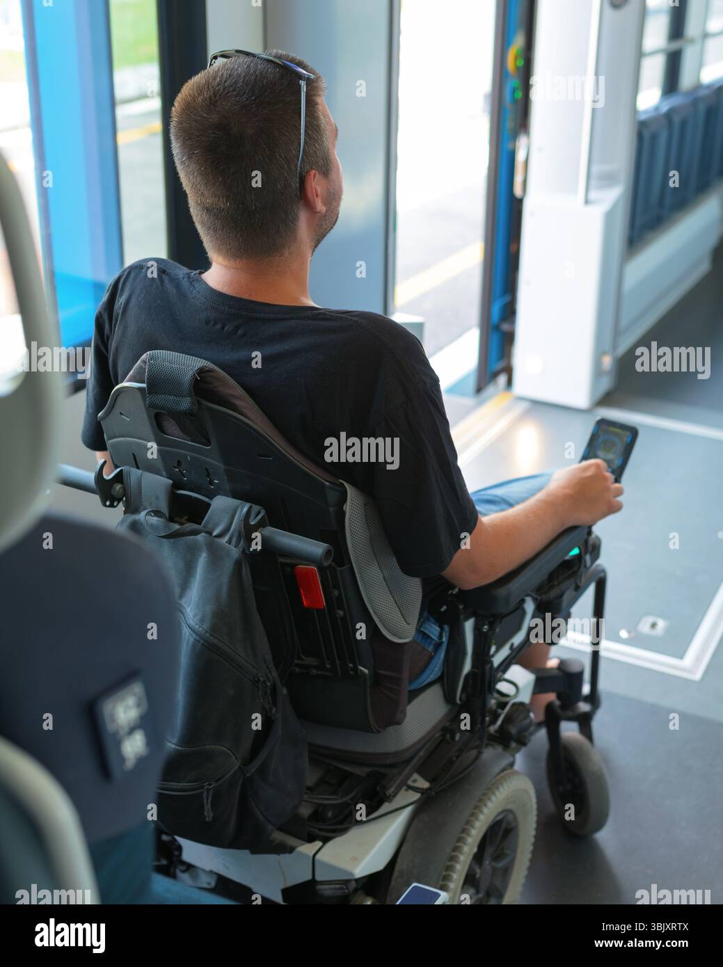 Man with disability is using a powered wheelchair while aboard a train ...
