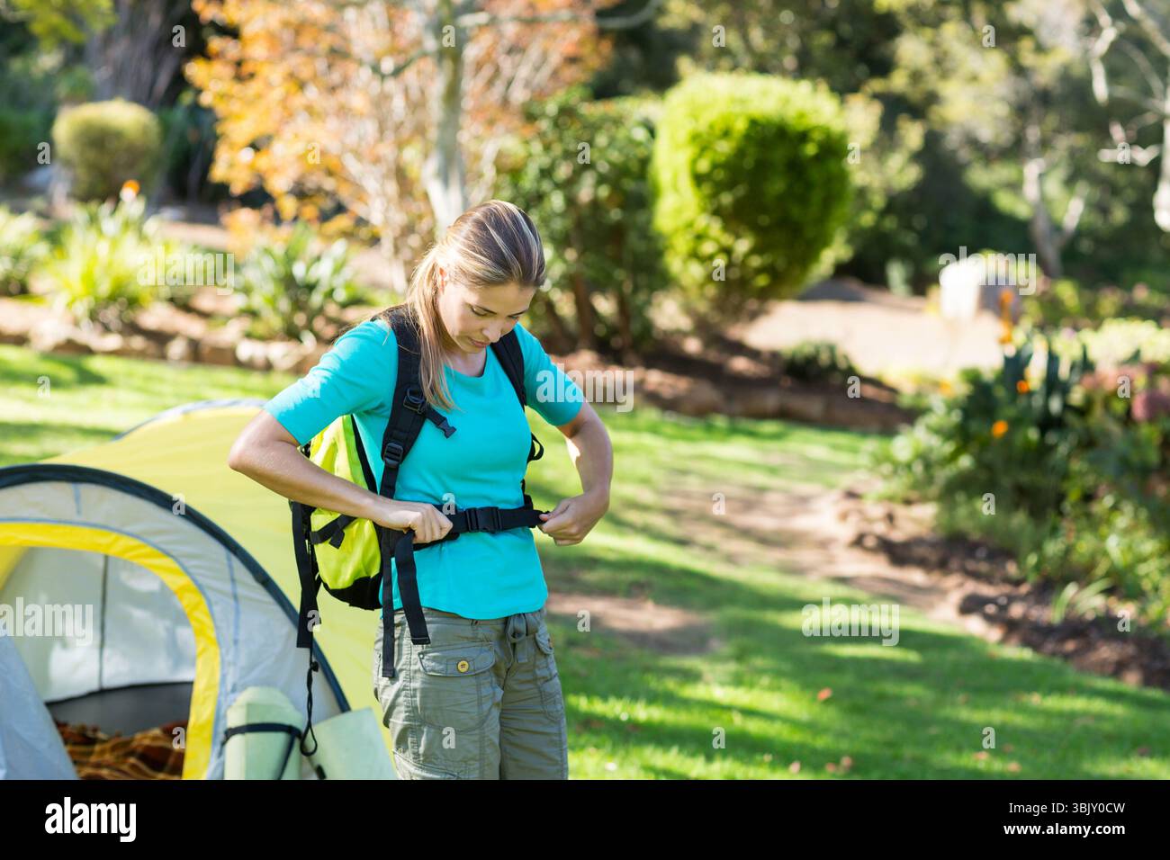 Yellow and gray tent standing under autumn trees, with black backpack ...