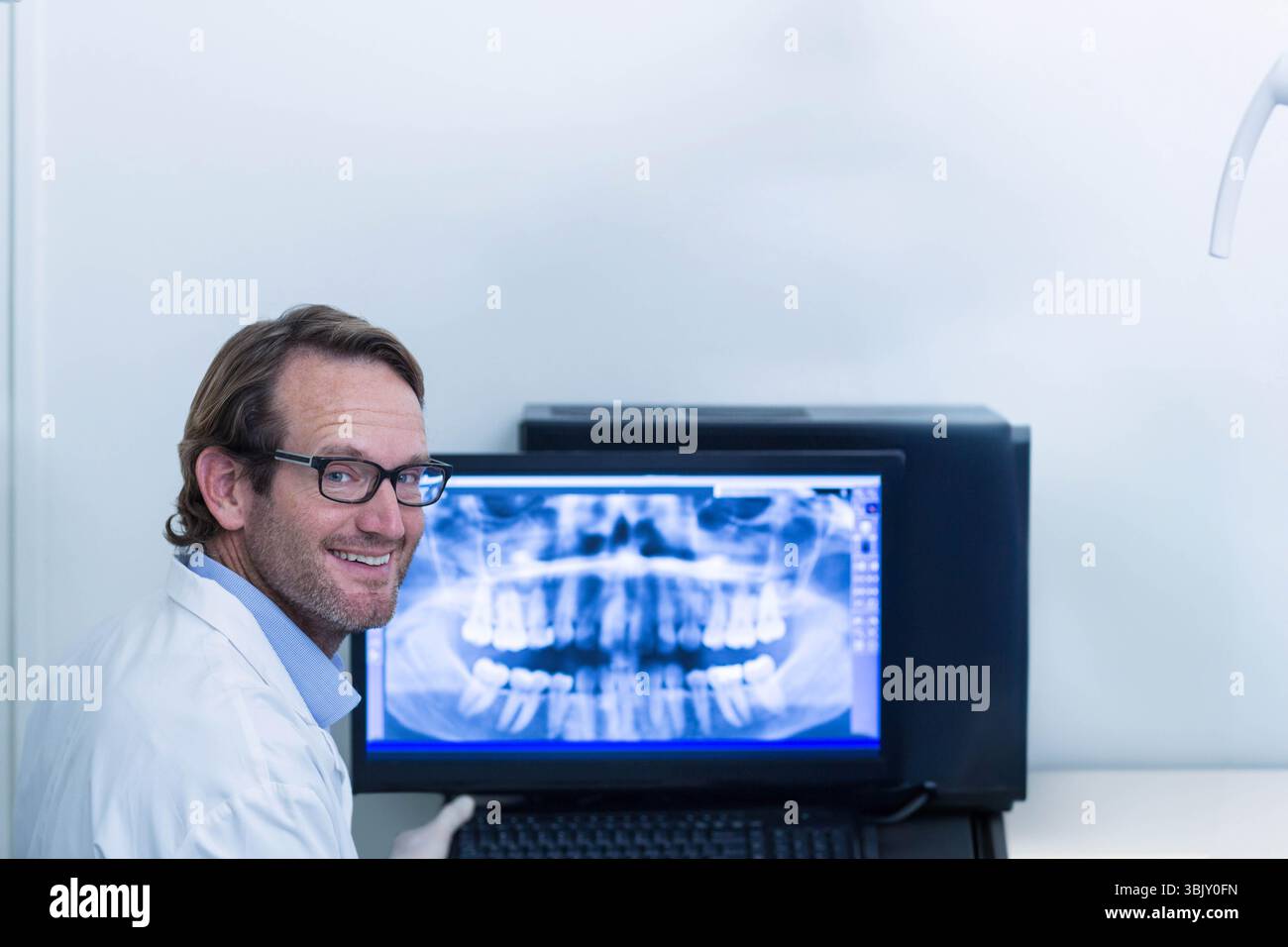 Computer workstation displaying panoramic dental X-ray in exam room ...