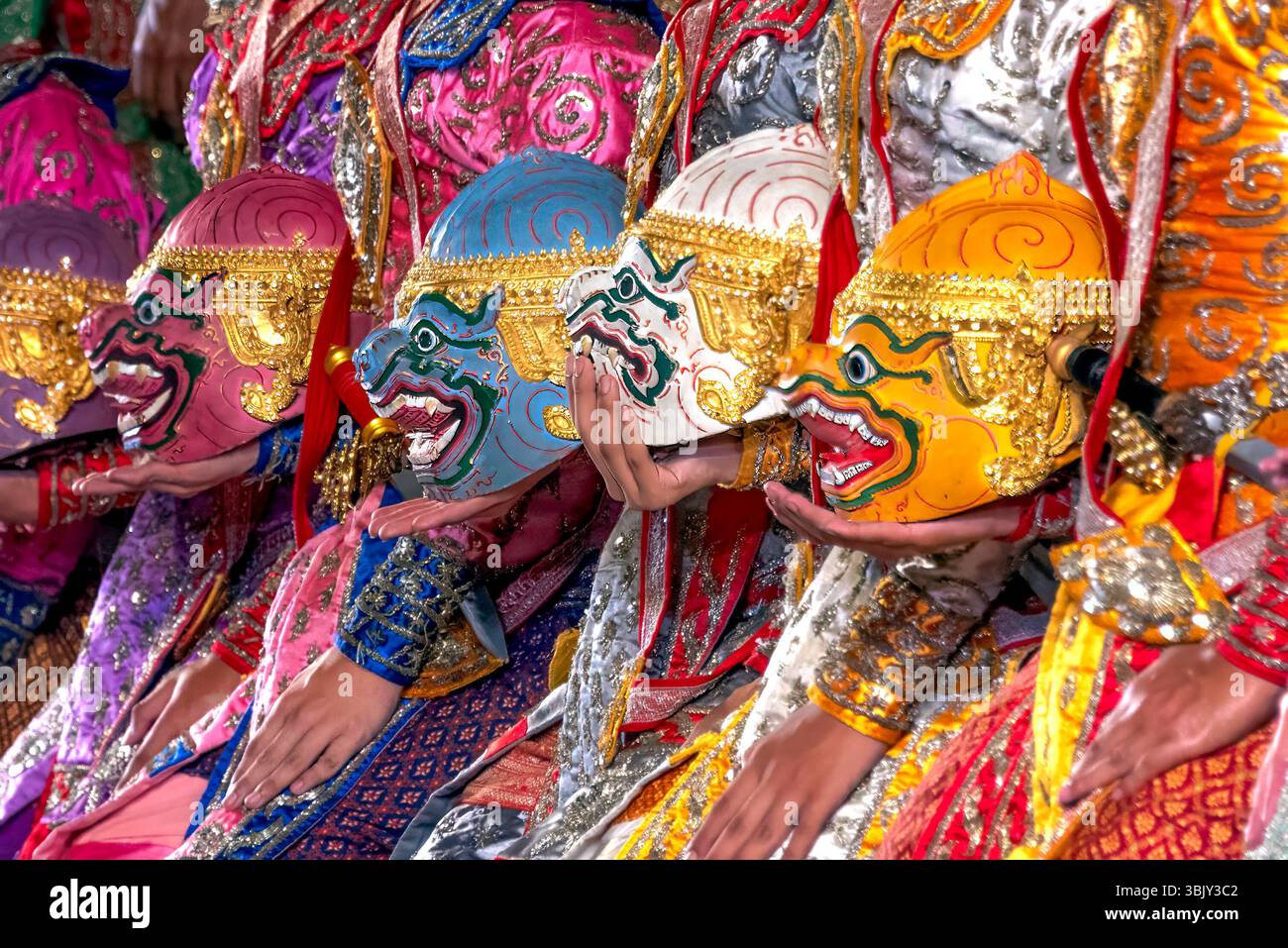 A line of performers in vibrant, elaborate traditional costumes hold ...