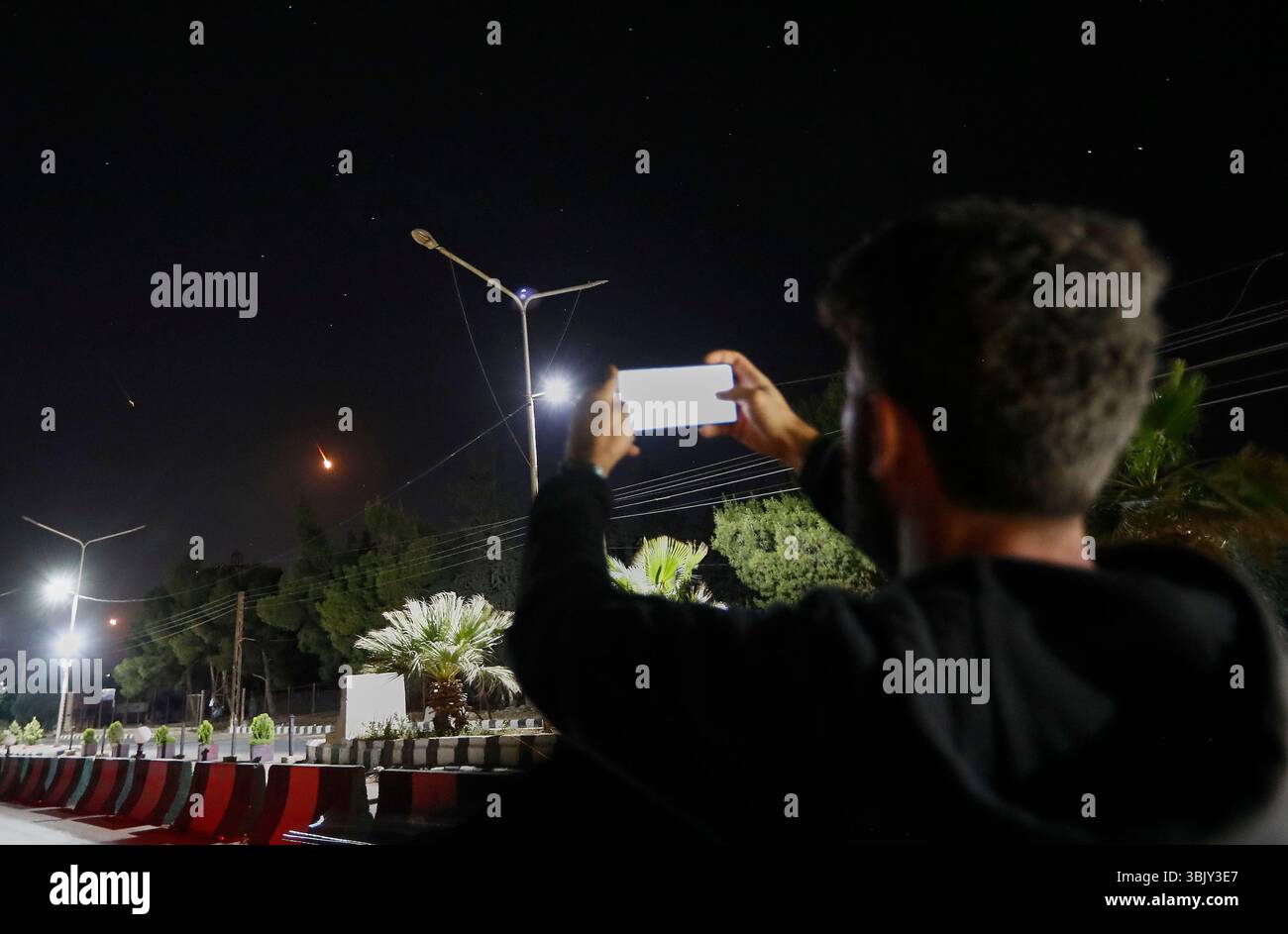 A Syrian man takes pictures with his mobile phone of Iranian missiles ...