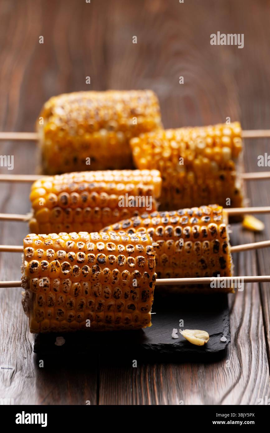 Slate tray with Pieces of Grilled corn on the cob on kitchen table ...