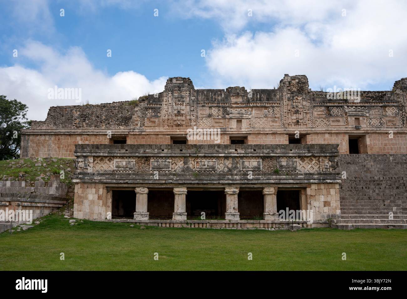 Maya Nunnery building with elaborate stone facade and multiple doorways ...