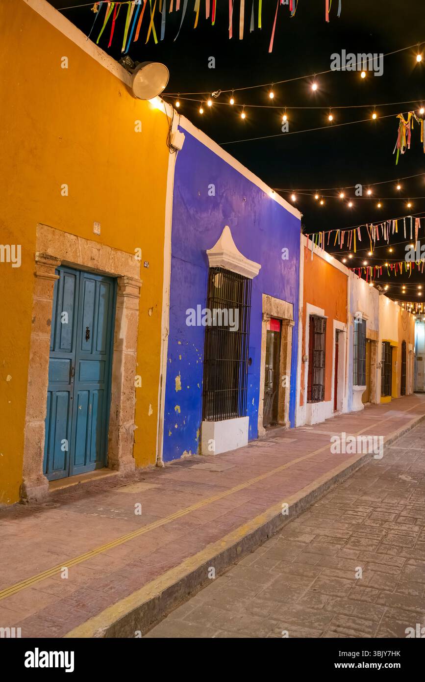 Colorful colonial street illuminated by string lights at night with ...