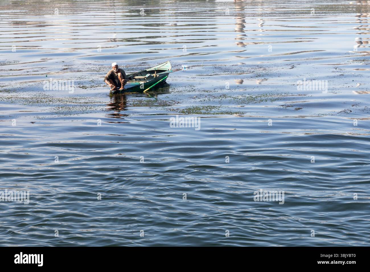 Squatting man in blue hi-res stock photography and images - Alamy