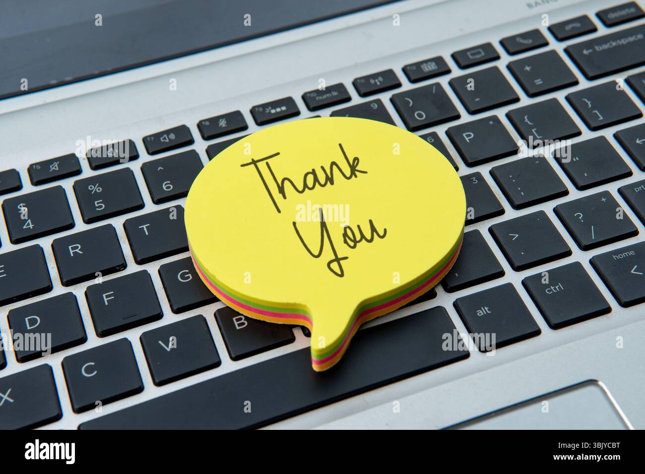 A sticky note with "Thank You" on top of a laptop keyboard. Gratitude ...