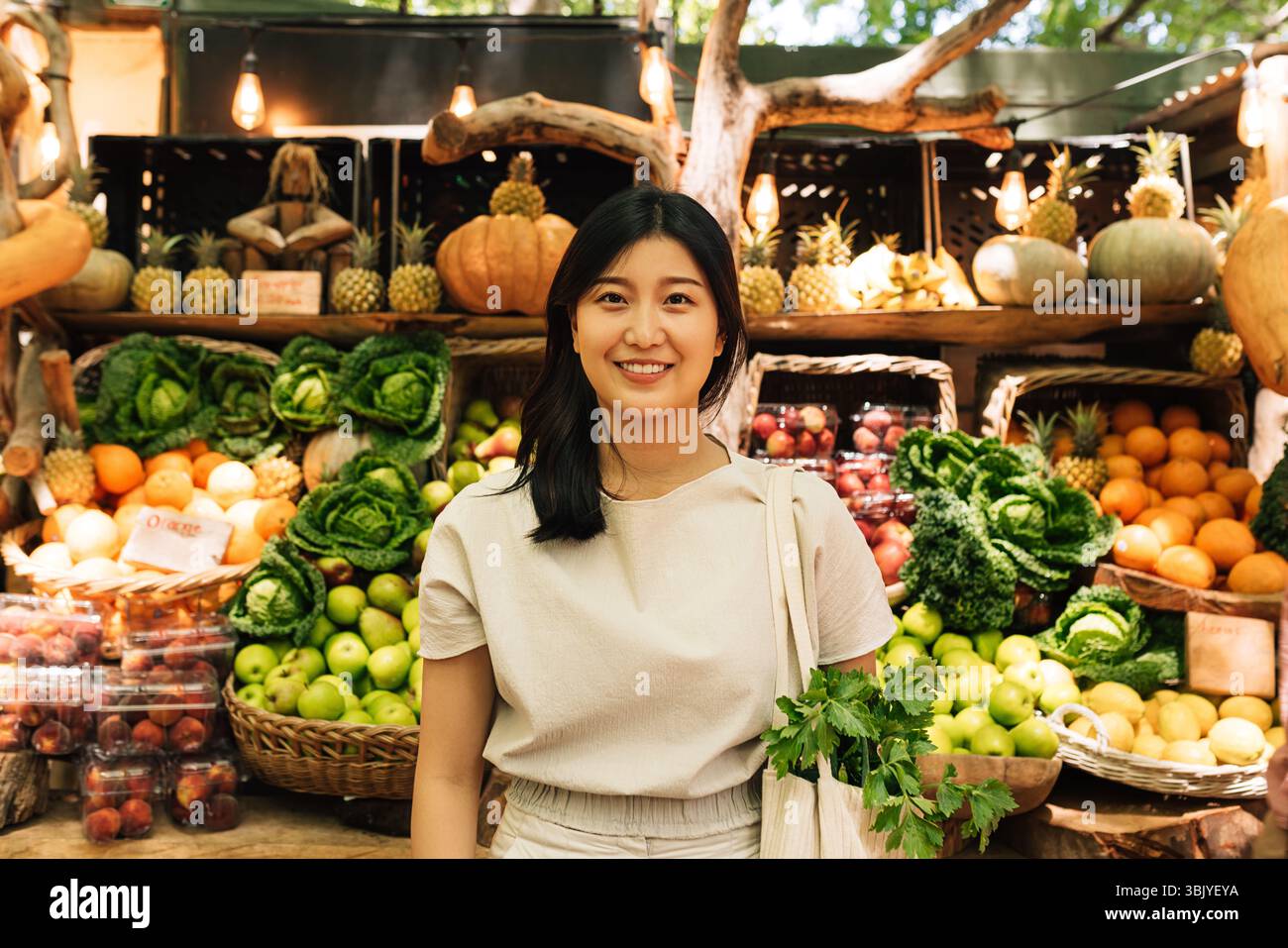 Portrait of a young Asian woman while standing at an outdoor market ...