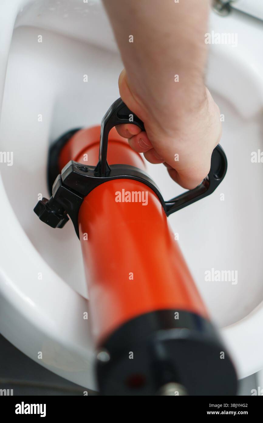 Plumber unclogging toilet hand hi-res stock photography and images - Alamy