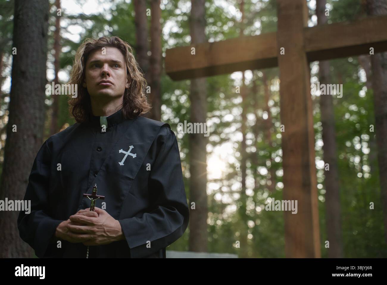 Christian priest with cross on the cemetery Stock Photo - Alamy