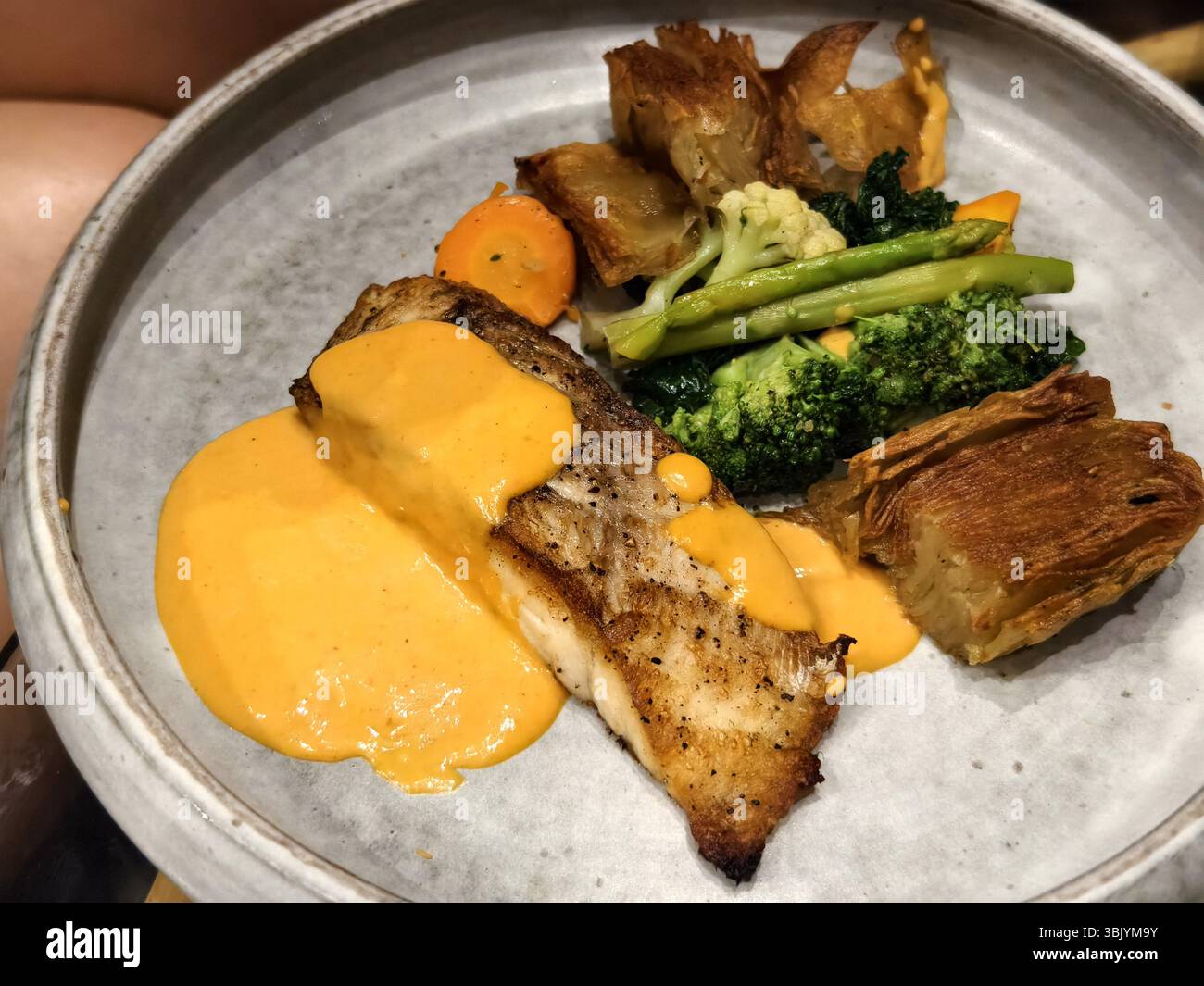 Grilled fish fillet with velvety orange sauce, served with crispy ...