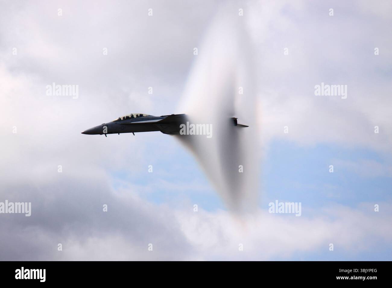 A U.S. Navy F/A-18 Super Hornet breaks the sound barrier, creating a ...
