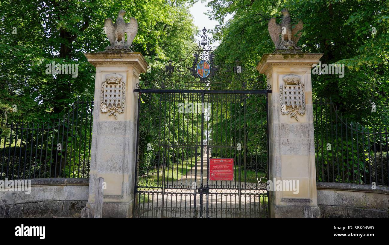 CAMBRIDGE, UK - JUNE 11, 2025 - Majestic wrought iron gate adorned with ...