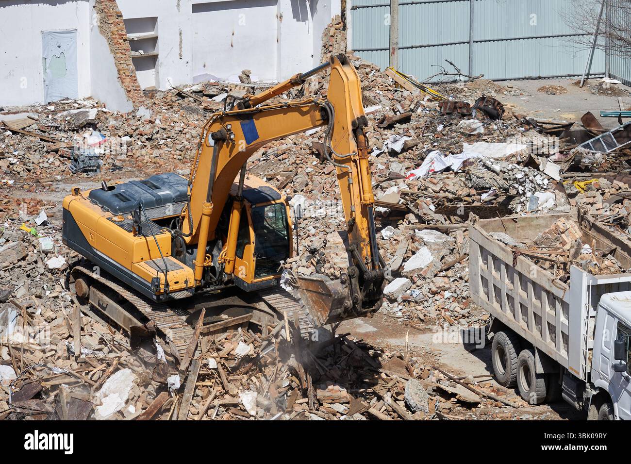 Excavator stands on rubble of house. Dismantling process, demolition of ...