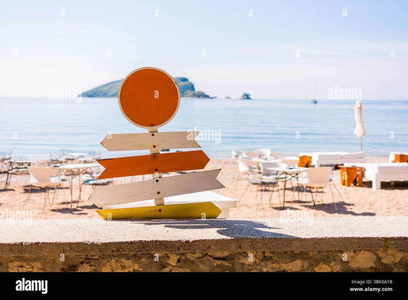 Wooden beach signpost with arrows on seaside promenade. Summer vacation ...