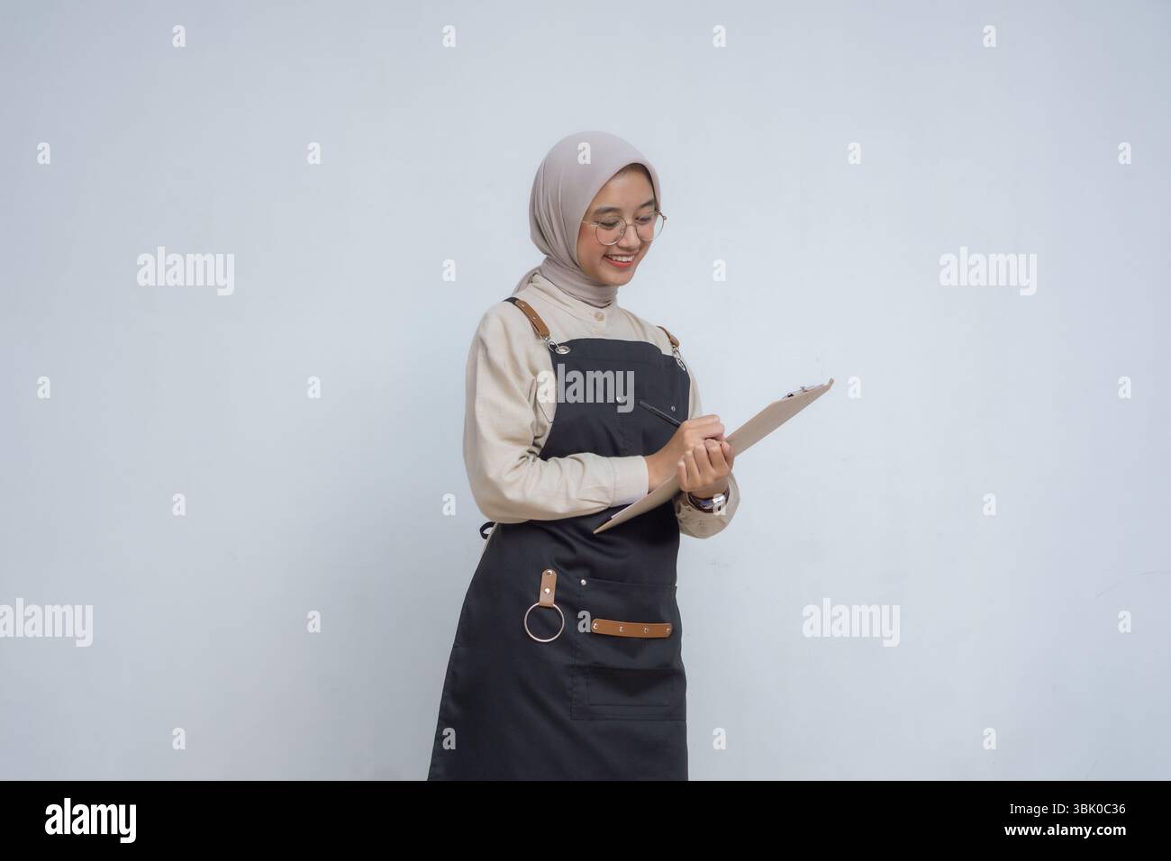Asian young muslim wearing hijab and black apron Stock Photo - Alamy