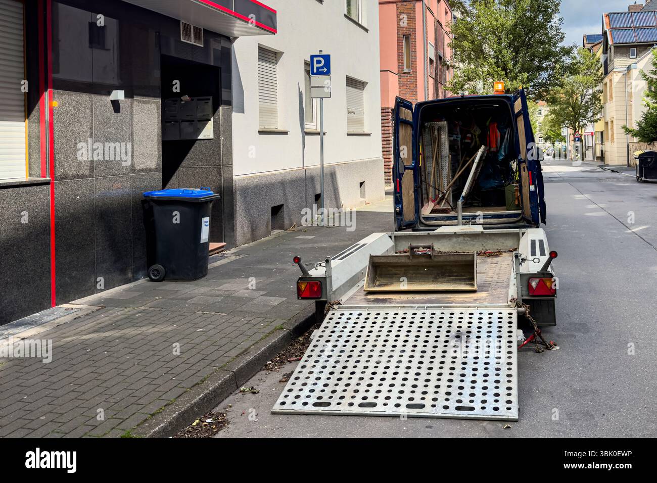 A delivery truck is parked with its ramp lowered on a city street ...