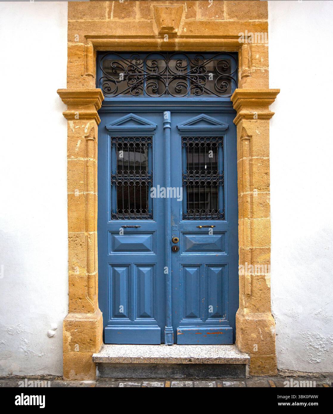 Traditional blue wooden door featuring intricate wrought iron grilles ...