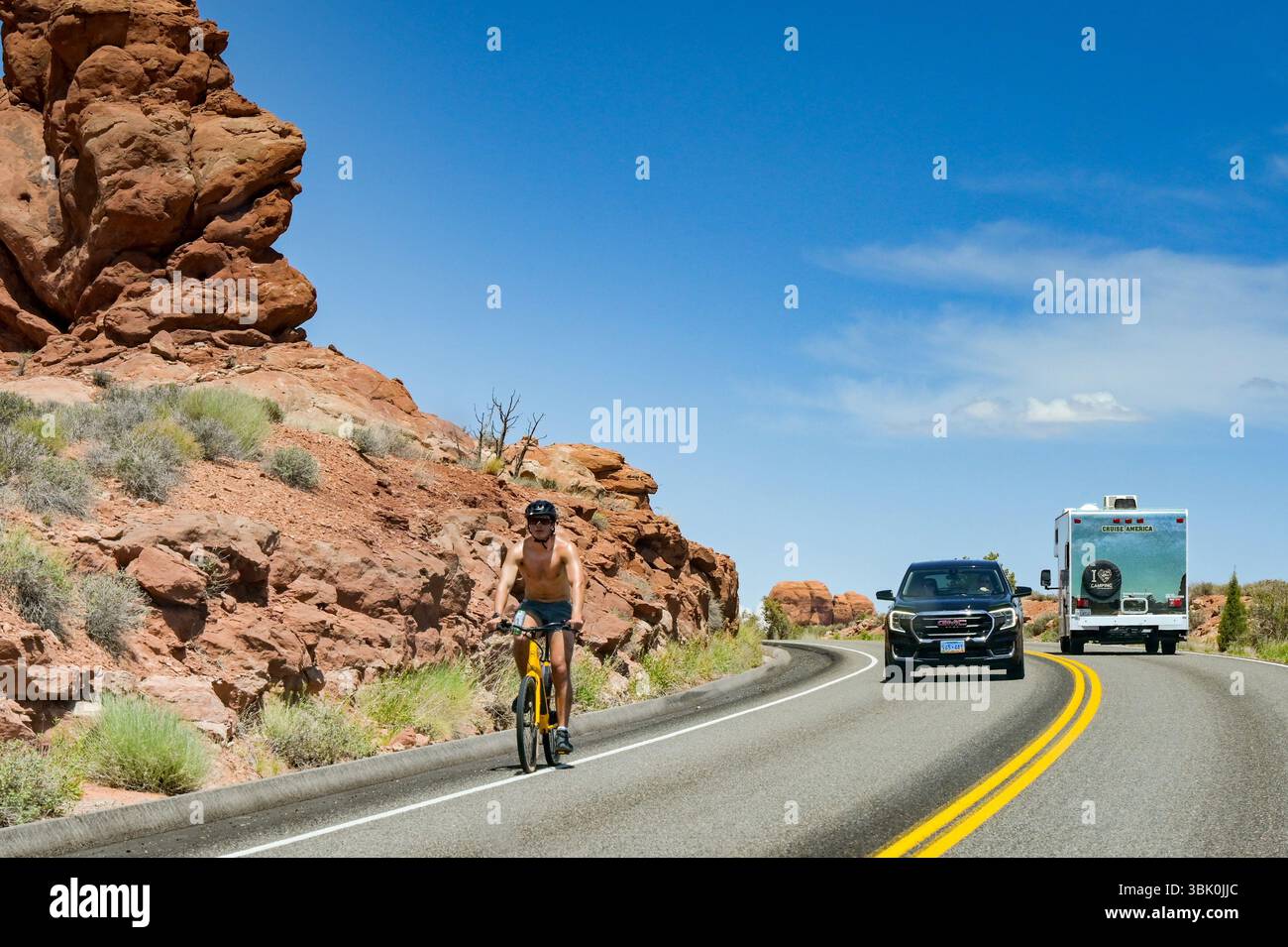 Moab, Utah, USA - 25 May 2025: Cyclist riding on a road with trafiic ...