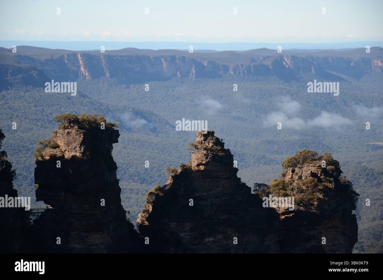 Three Sisters rock formation with misty blue mountains backdrop ...