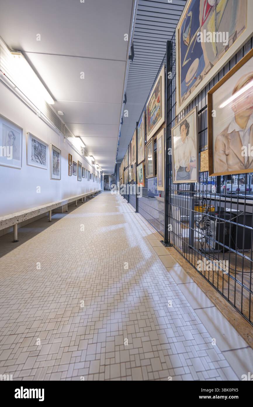 Long corridor in a gallery, lined with works of art on the walls ...