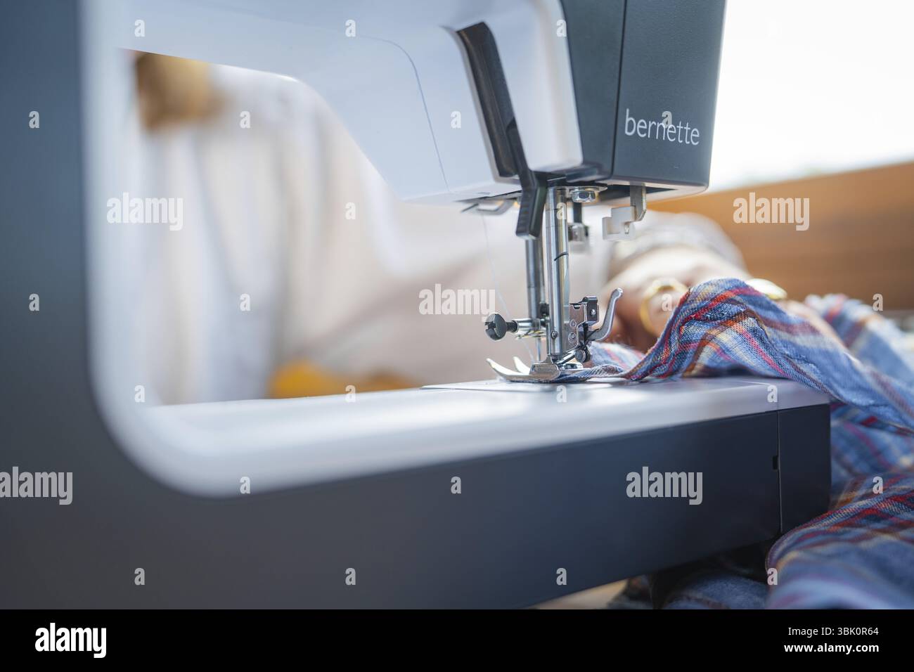 Details of the sewing process with needle and fabric in a well-lit ...