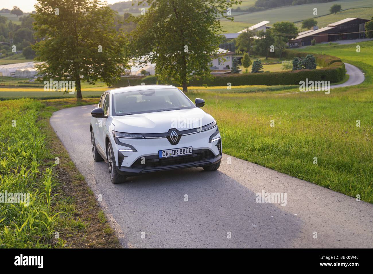 Electric car driving on a rural road, surrounded by green nature and trees, Renault Megane, Deer ...