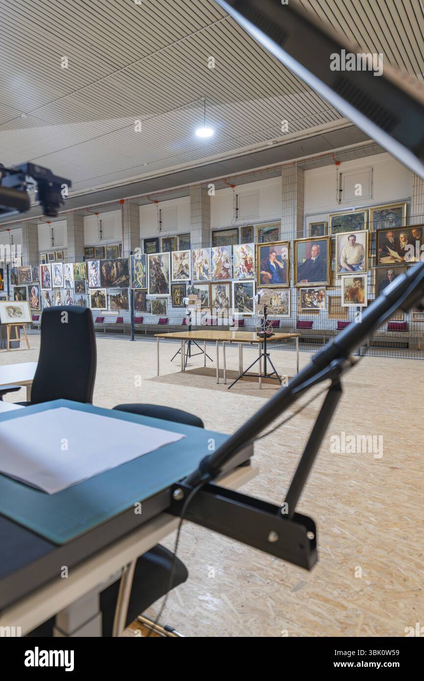 Exhibition gallery with artworks, stands and tables in the interior ...