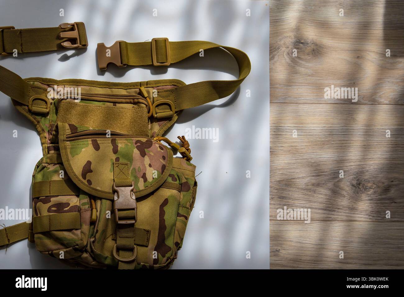 Military-style camouflage utility pouch with tactical belt. Close-up of ...